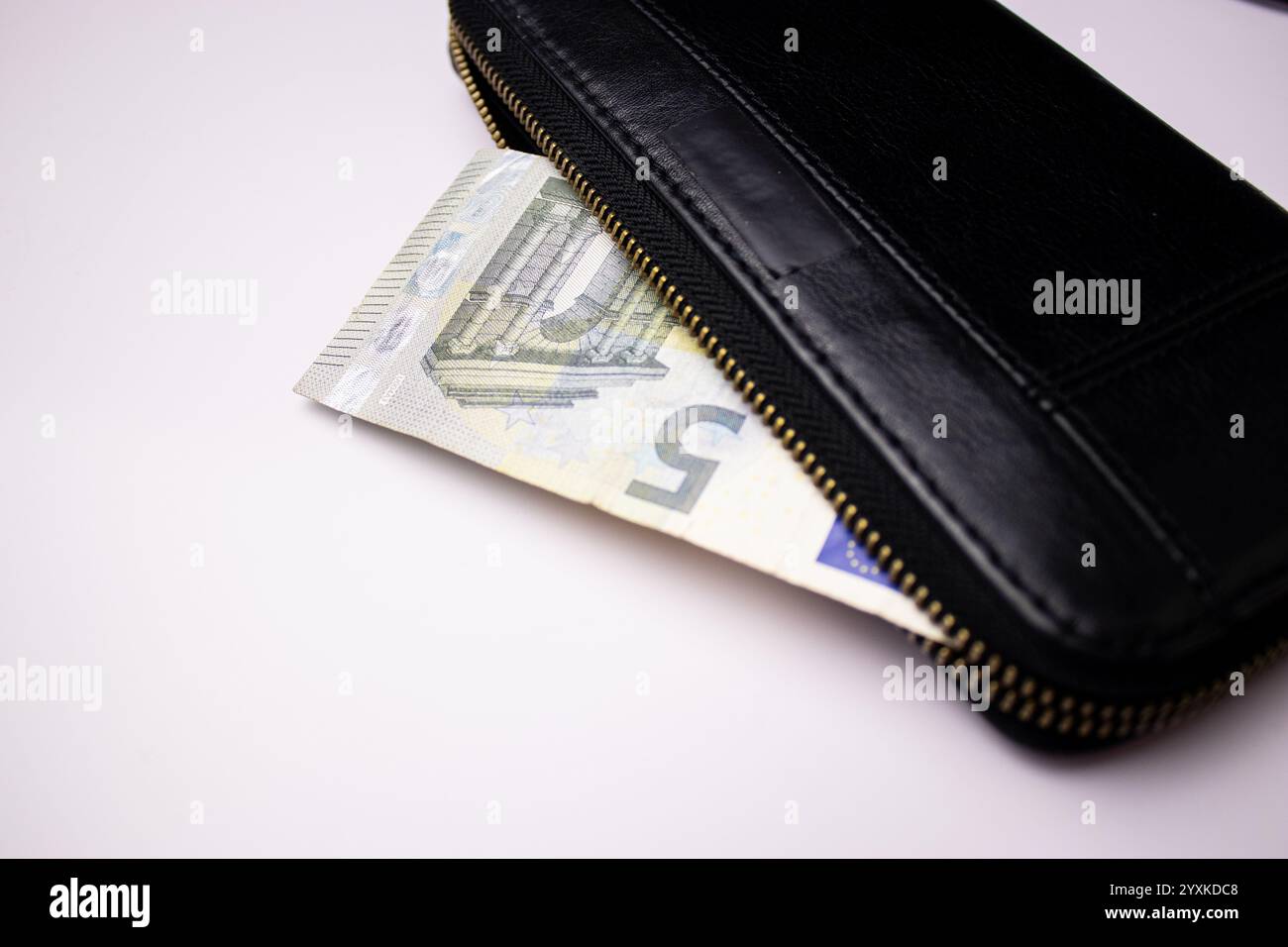 Black leather wallet with five euro bills banknotes on white background ...