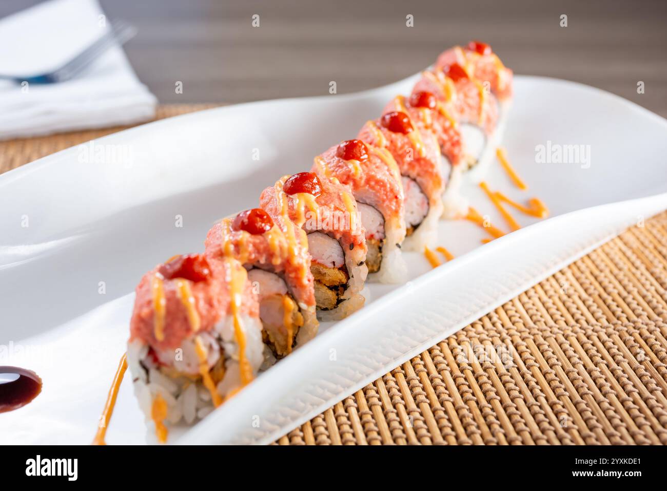 A view of a colorful sushi roll with tempura shrimp and imitation crab ...