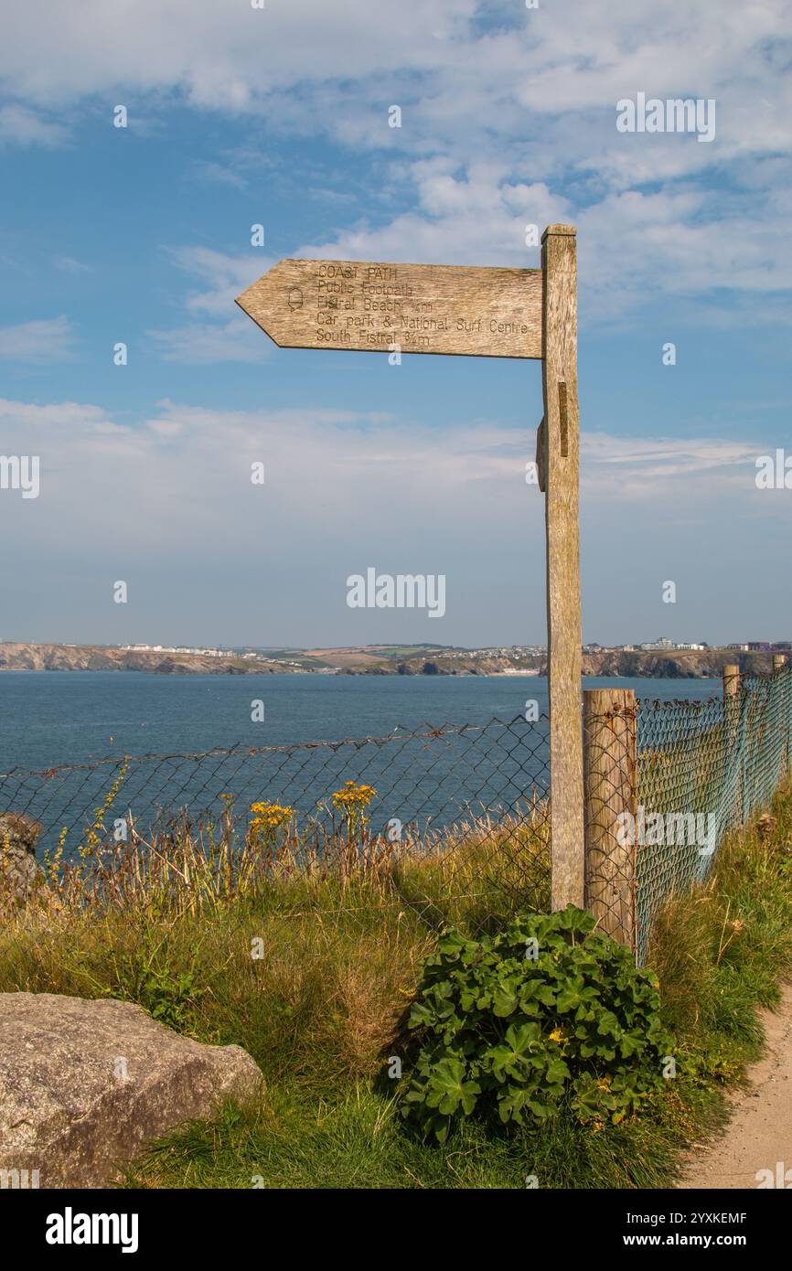 A wooden sign post shows the way of the South West Coast Path near ...
