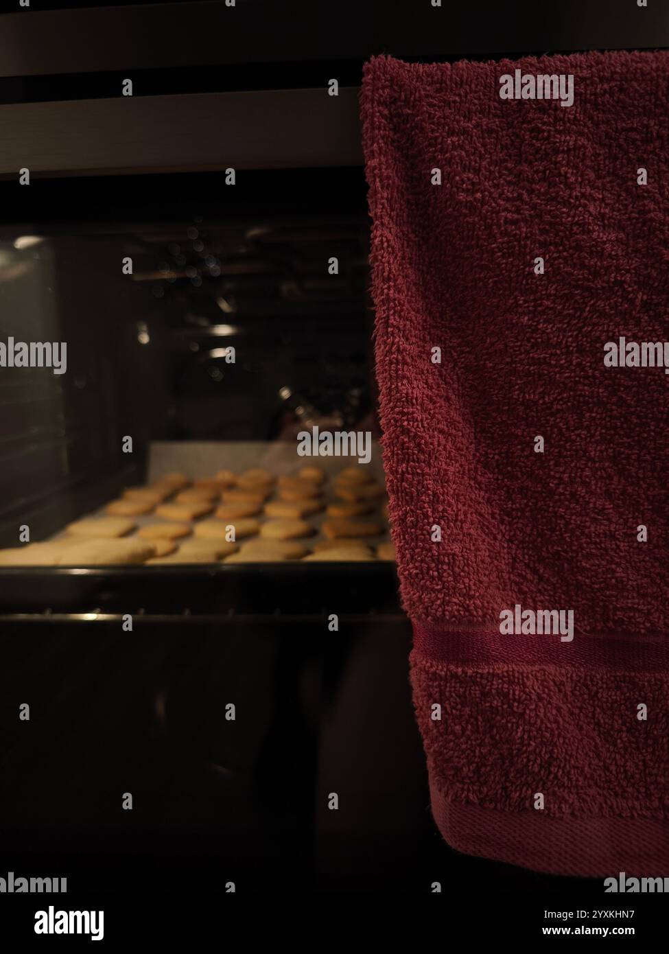 Heart shaped cookies baking in oven for valentine's day with red towel ...
