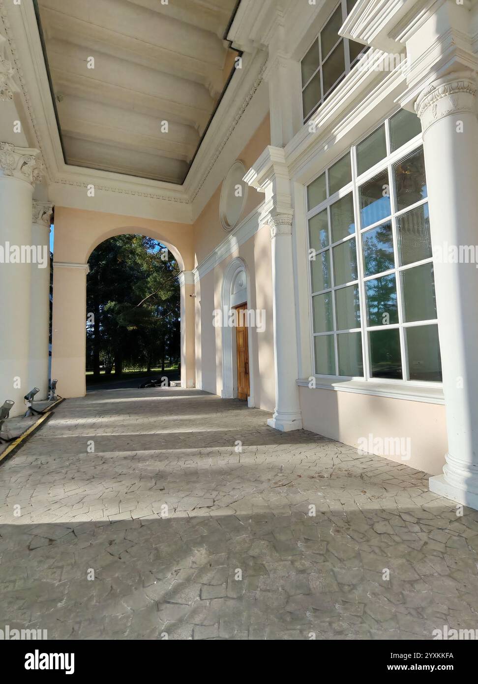 A neoclassical colonnade with tall white pillars, large windows, and ...