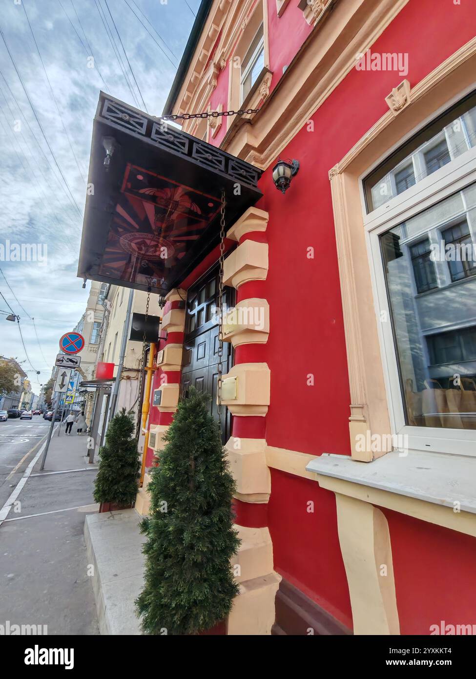 Vibrant red facade of a building with beige architectural details ...