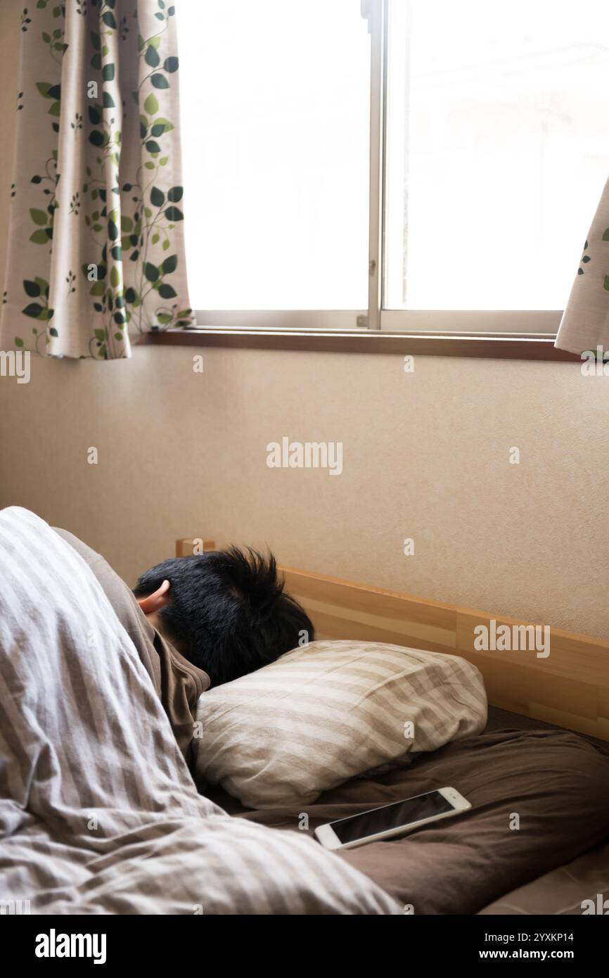 Man sleeping on futon Stock Photo - Alamy