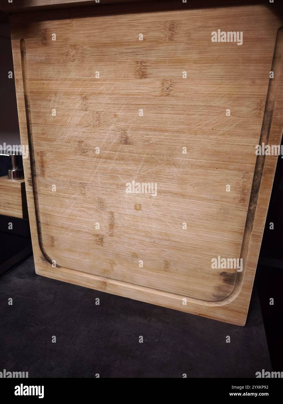 Used bamboo cutting board showing signs of wear and tear in kitchen ...
