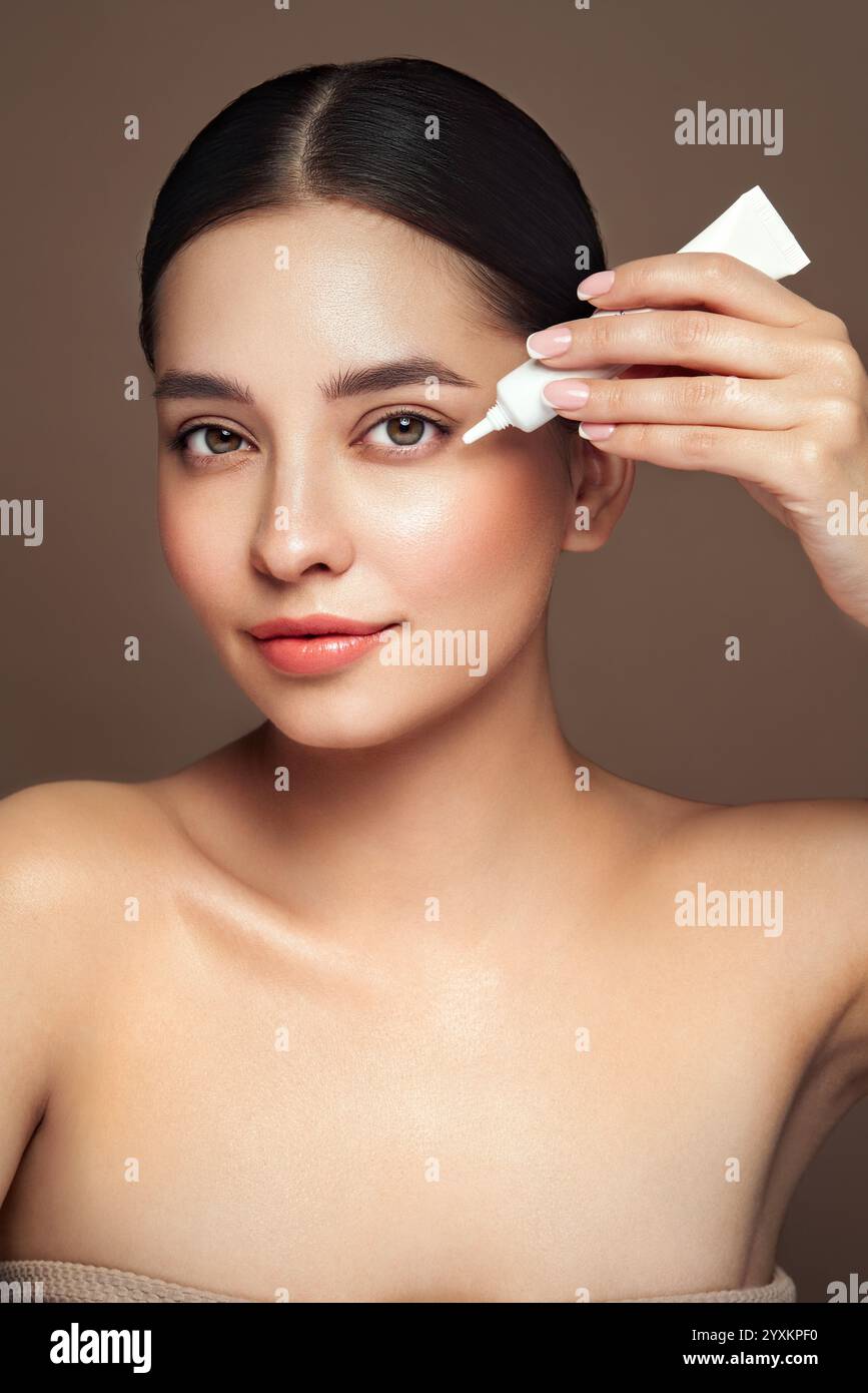 Beautiful woman using cream around the eyes. Video of woman with ...