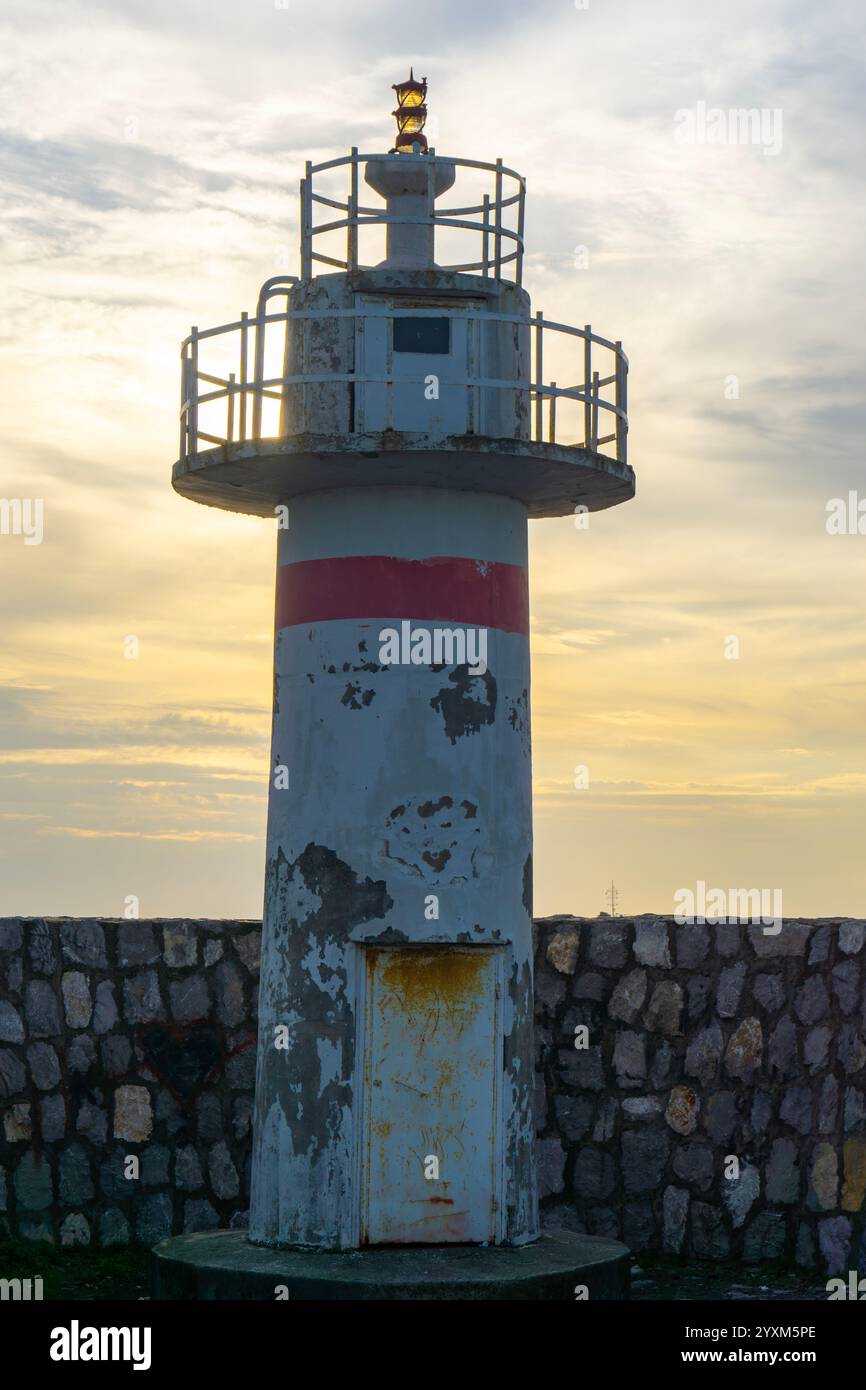 A weathered lighthouse with twilight sky background in sunset time. The ...
