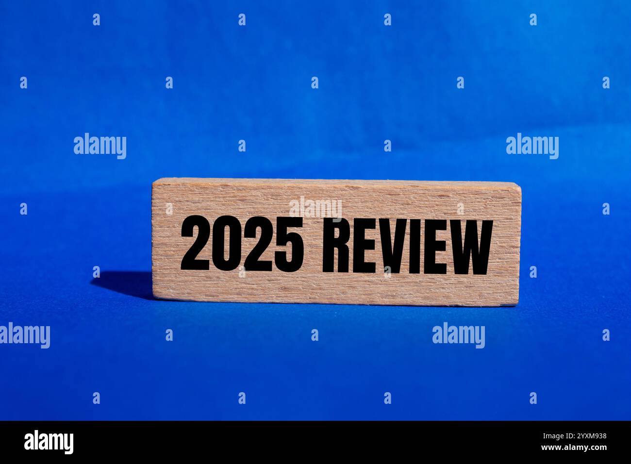 2025 review message written on wooden block with blue background. Conceptual 2025 review symbol ...