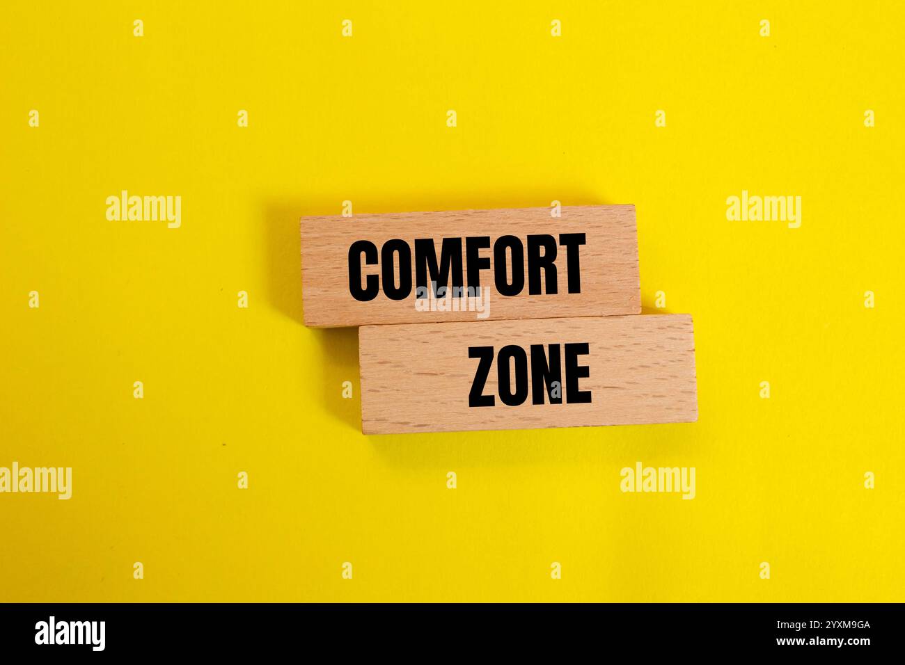Comfort zone message written on wooden blocks with yellow background. Conceptual comfort zone ...