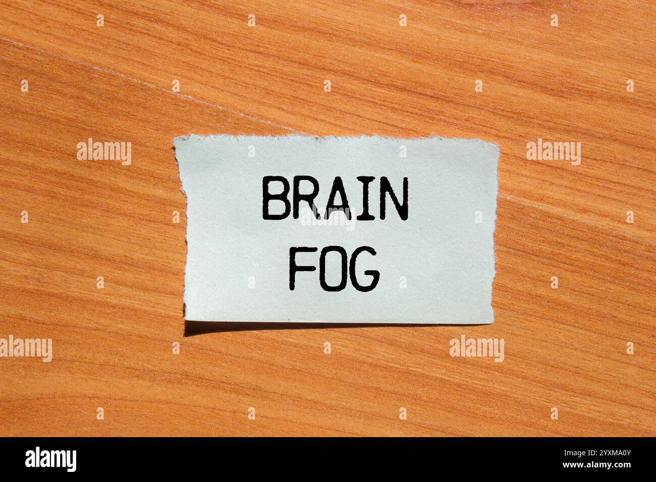 Brain fog message written on ripped torn paper piece with wooden ...