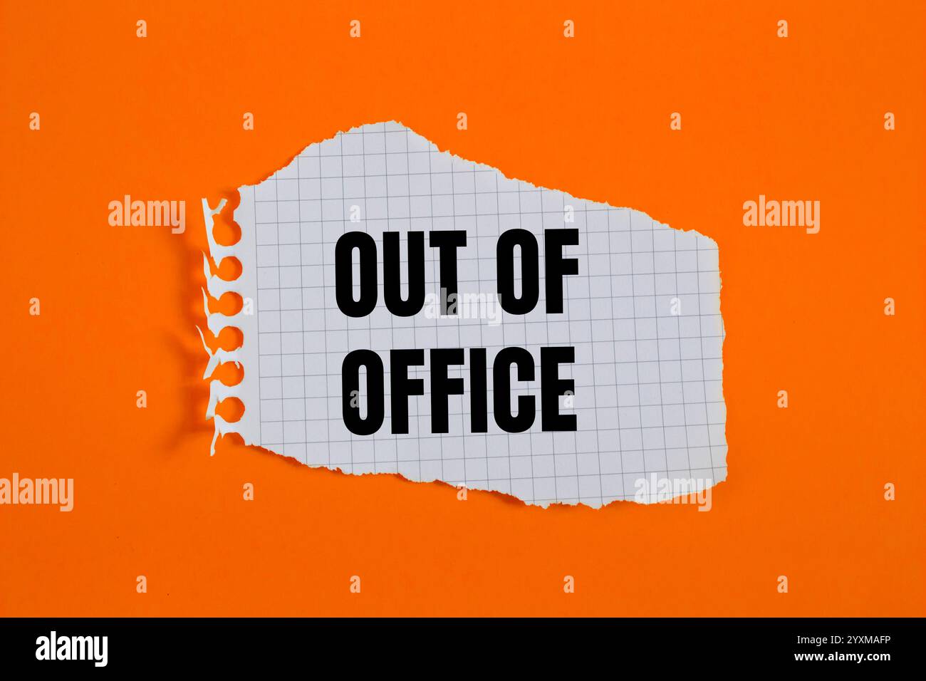Out of office message written on ripped torn checkered graph paper ...