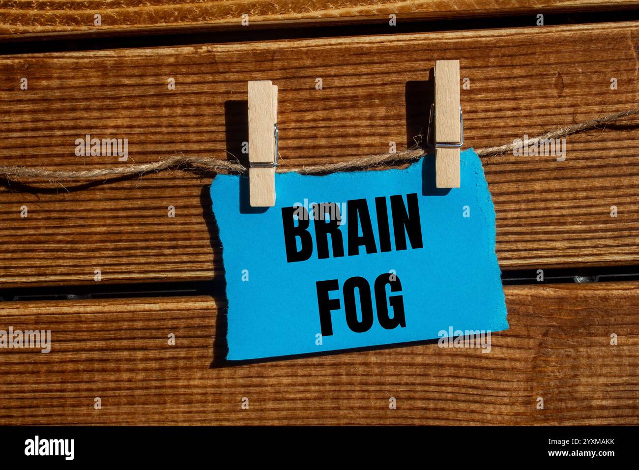 Brain fog message written on ripped blue torn paper piece with wooden ...