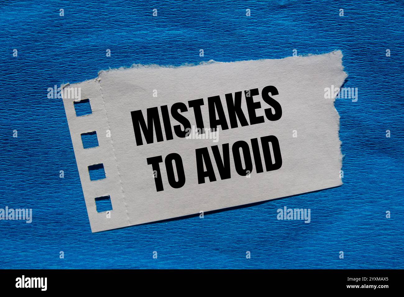 Mistakes to avoid message written on ripped torn paper piece with blue ...
