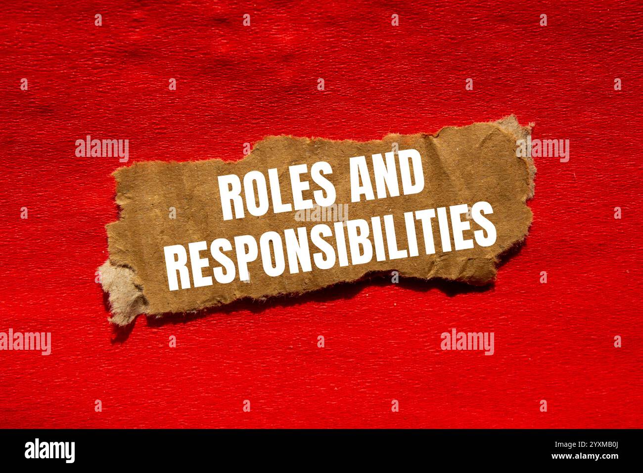 Roles and responsibilities message written on ripped torn cardbaord ...