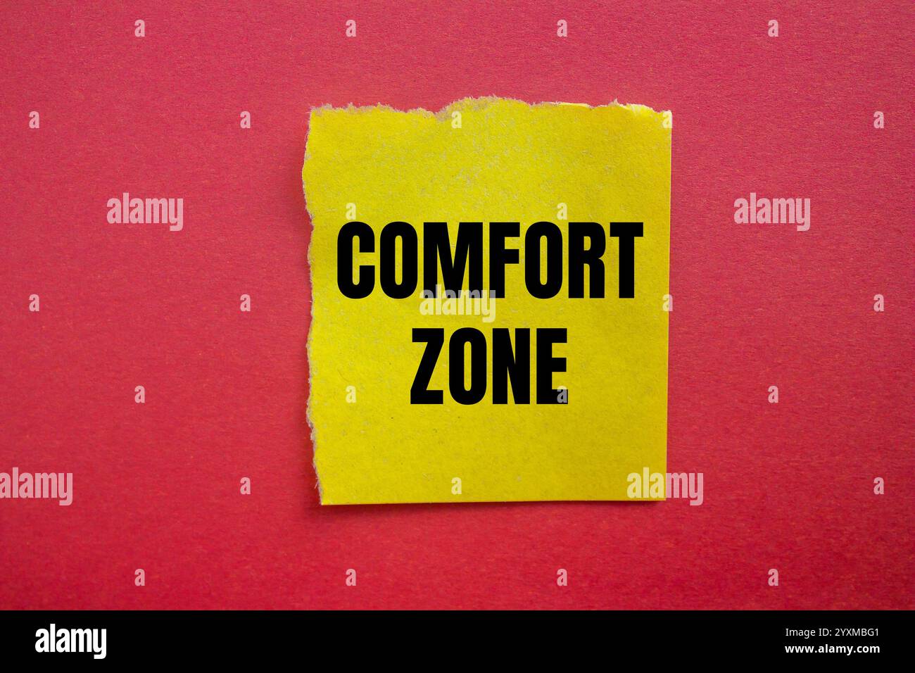 Comfort zone message written on ripped torn yellow paper piece with red background. Conceptual ...