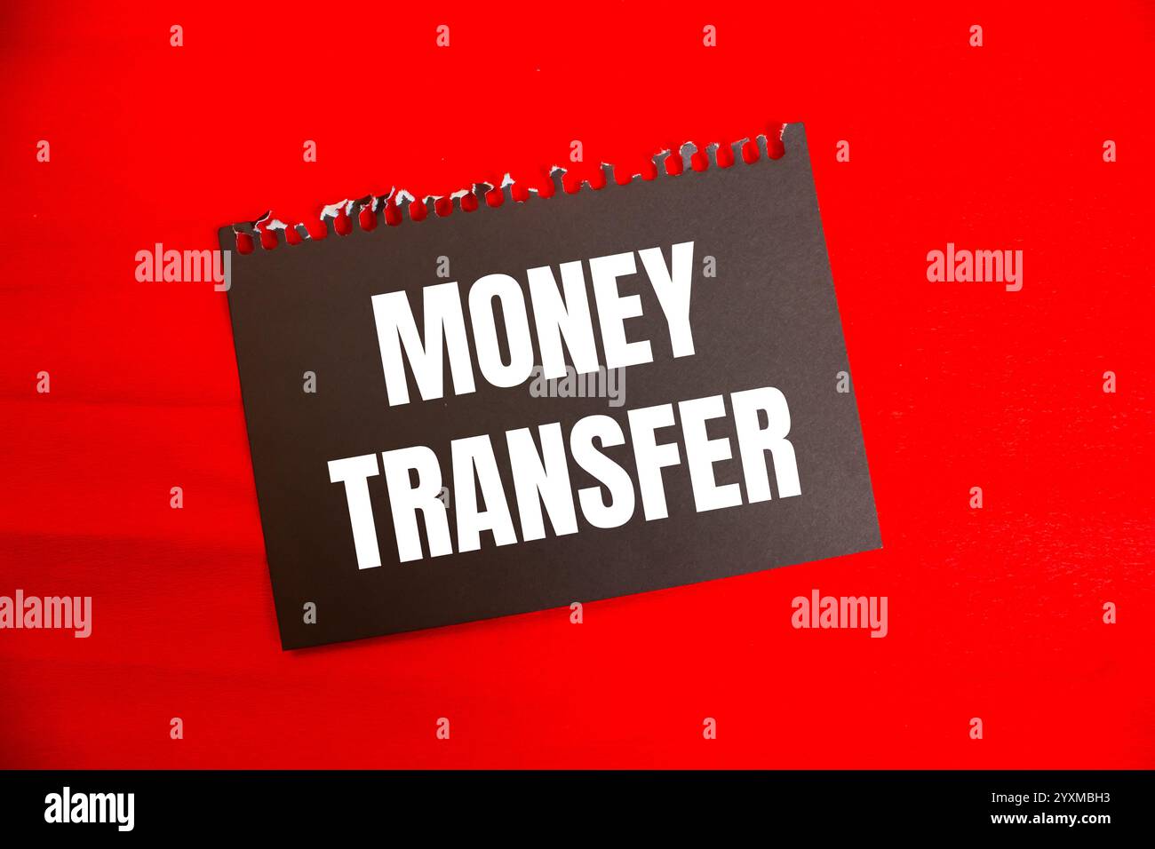 Money transfer message written on black paper with red background ...