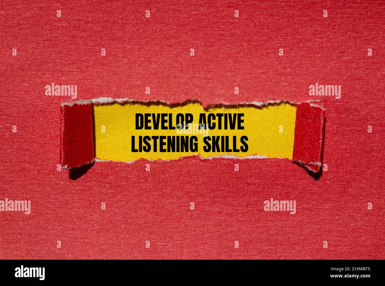 Develop active listening skills message written on ripped torn red paper with yellow background ...