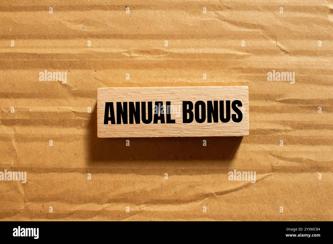 Annual bonus message written on wooden block with cardboard background ...