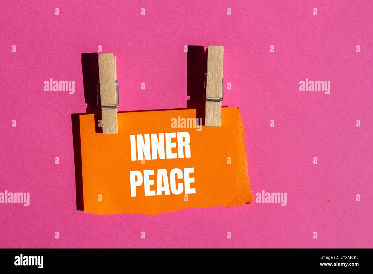 Inner peace message written on ripped torn orange paper piece with pink ...