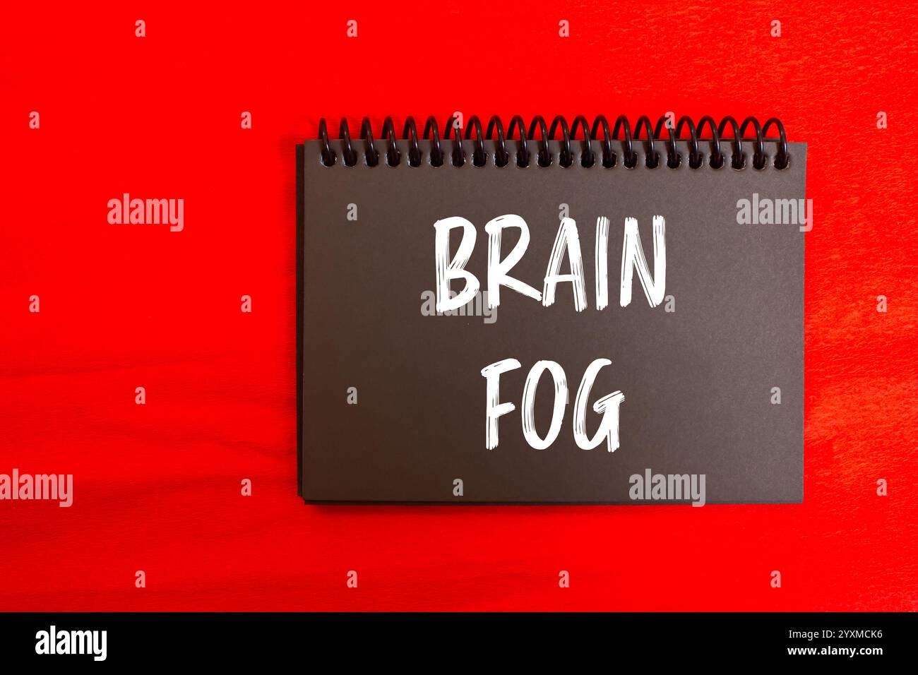 Brain fog message written on black notebook page with red background ...