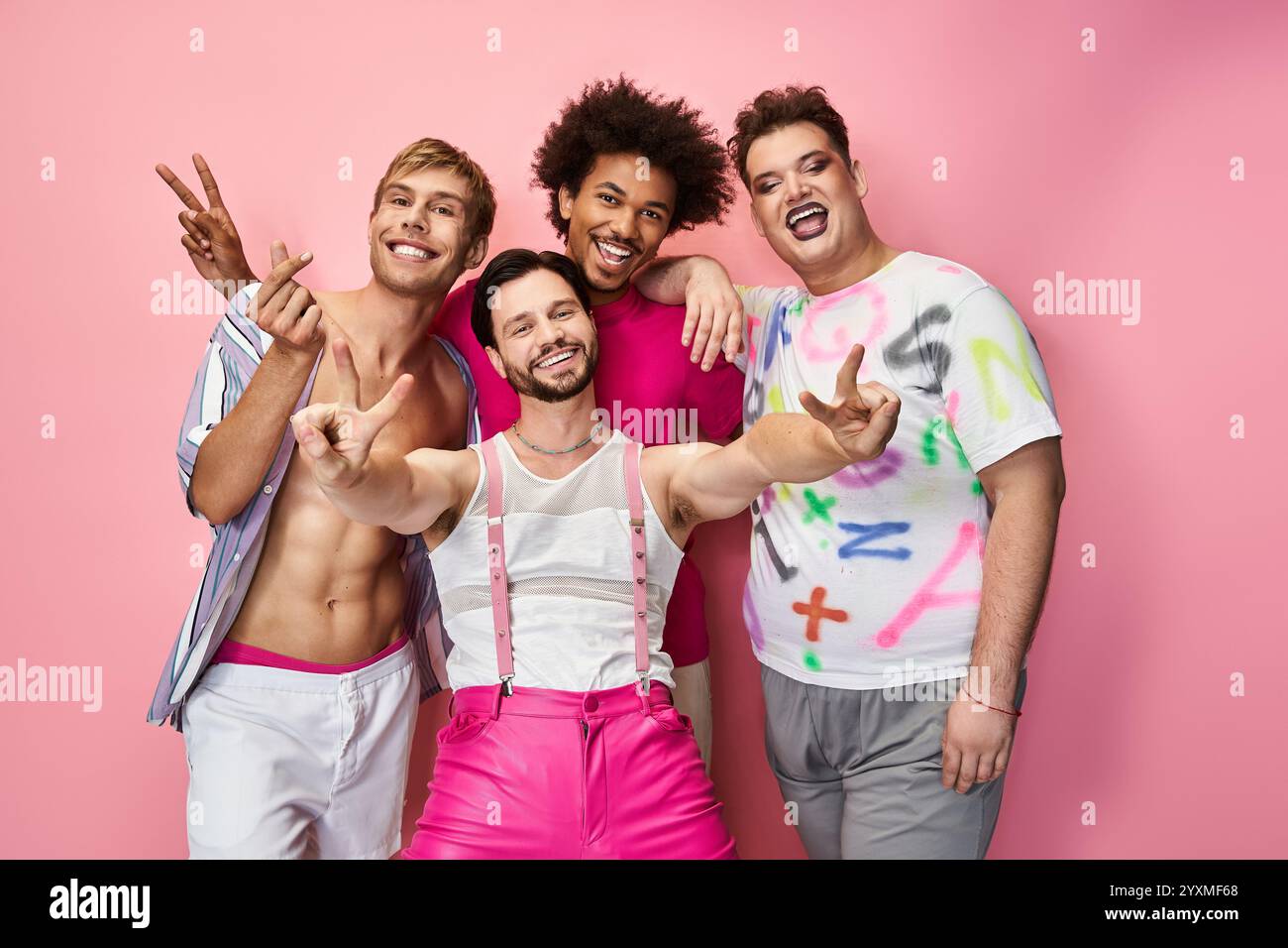 A joyful group of queer friends poses playfully against a bright pink ...