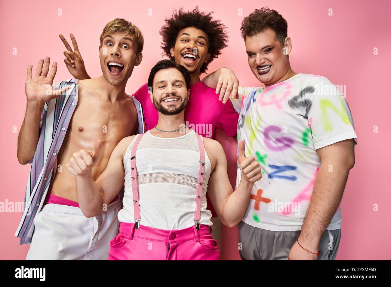 Four friends express joy and pride with colorful outfits against a pink ...