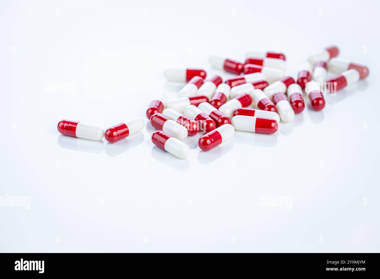 Red and white capsule pills spread on white background. Prescription ...
