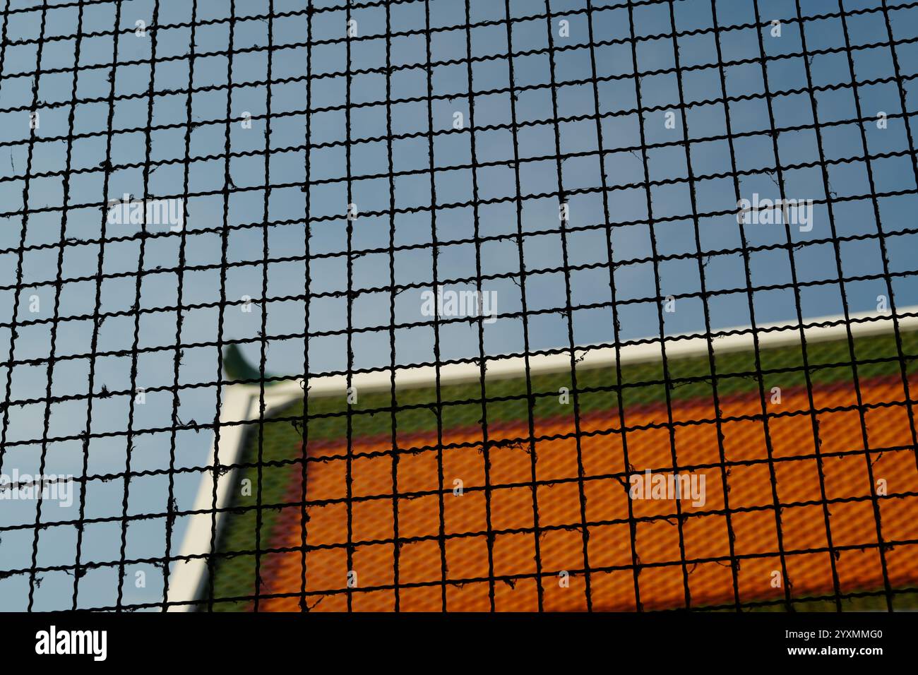 steel mesh window texture against the background of a blue sky and roof ...
