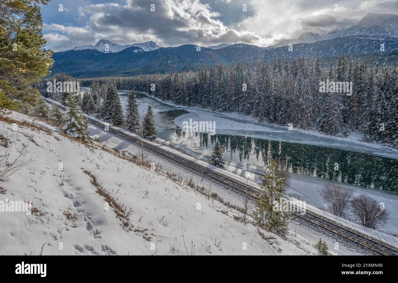 Snow falling over the Bow River and Train Track in Banff National Park ...