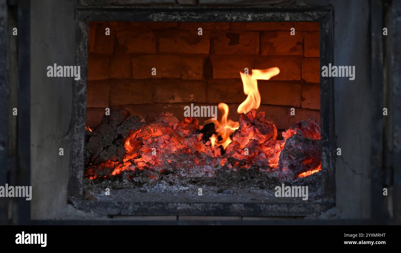 Burning wood and ashes with flame inside an old brick oven in ...