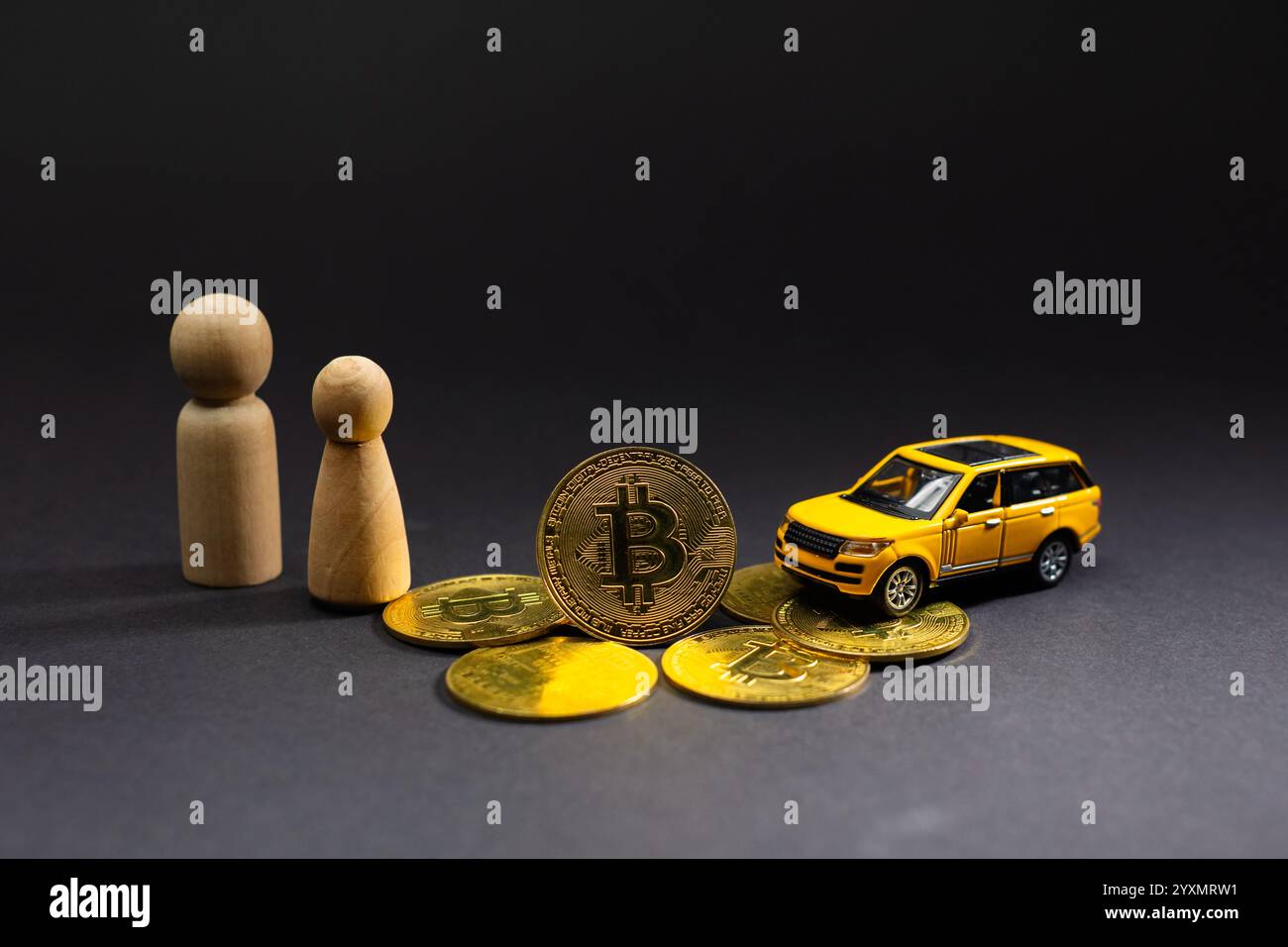 Wooden family figures standing next to pile of golden bitcoins and toy ...