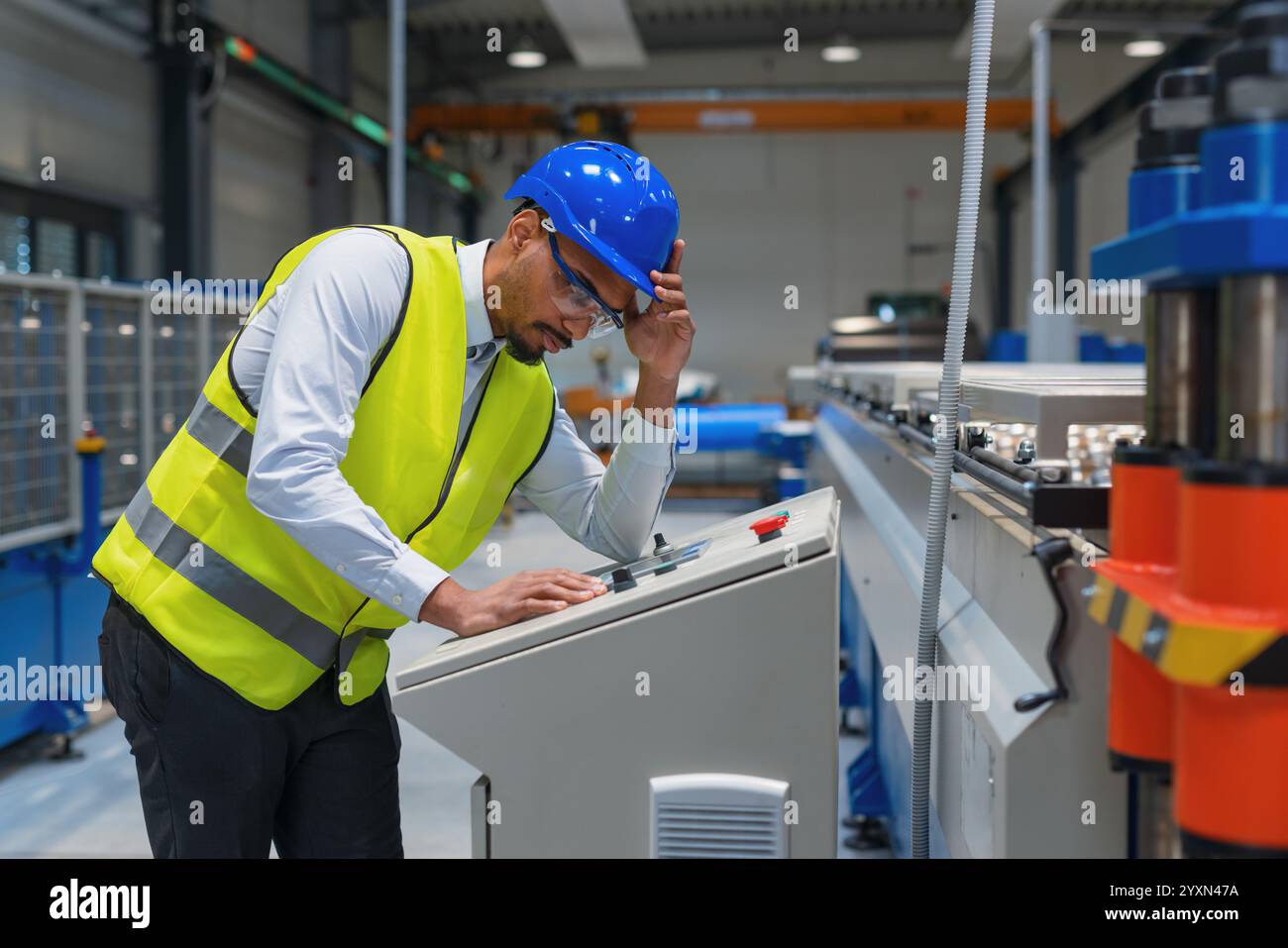 Sad and angry production line engineer at work in industrial factory ...