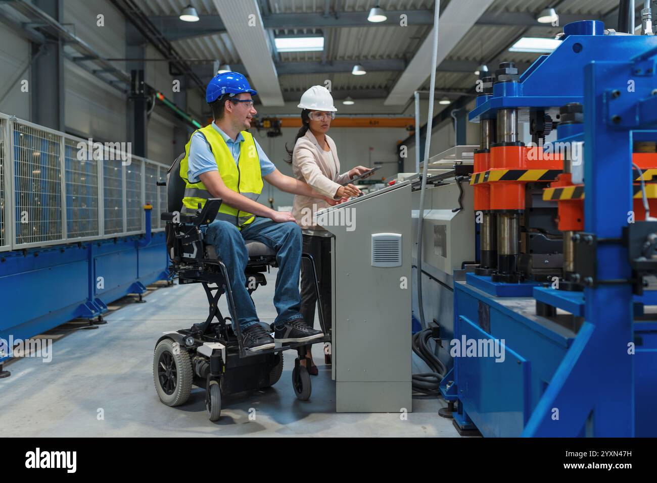 Indian female factory boss training male worker with a disability, in ...