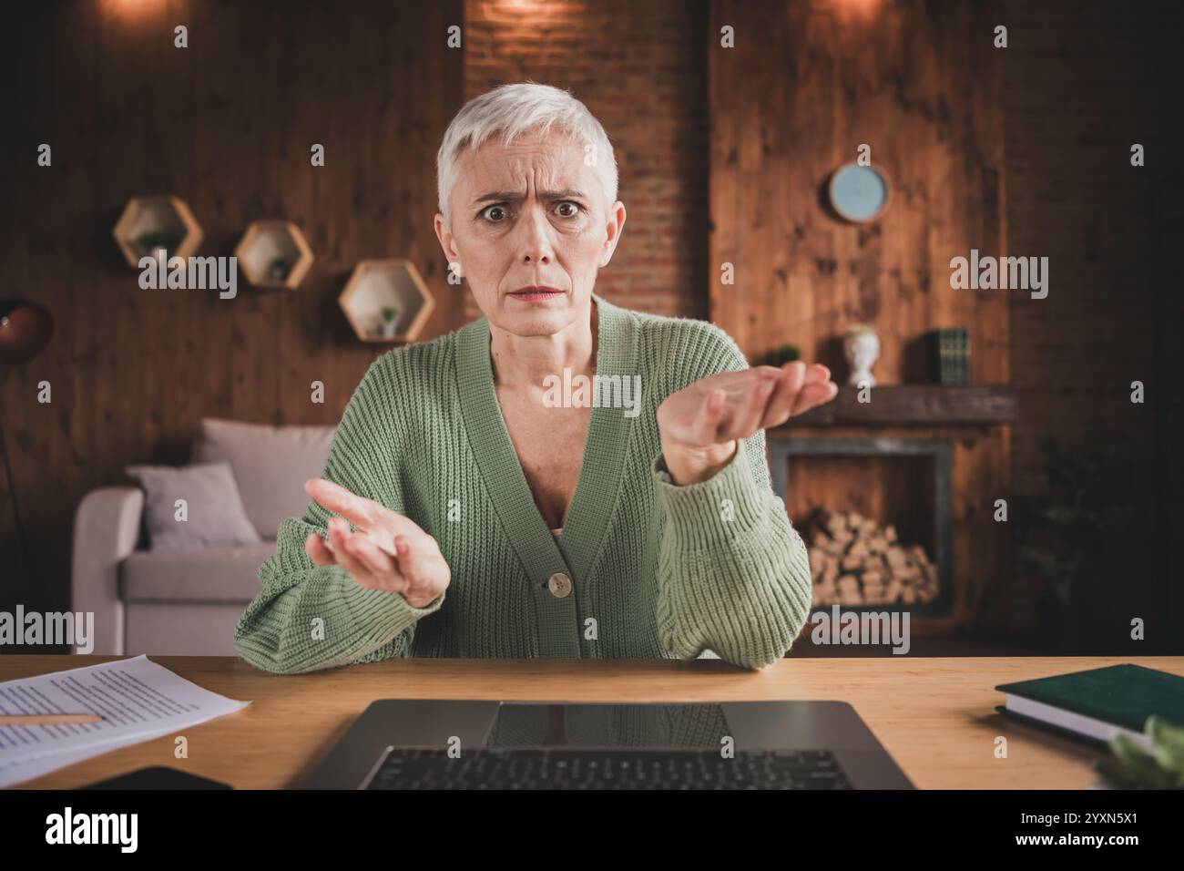 Elderly woman with short hair in a green knitted sweater questioning in ...
