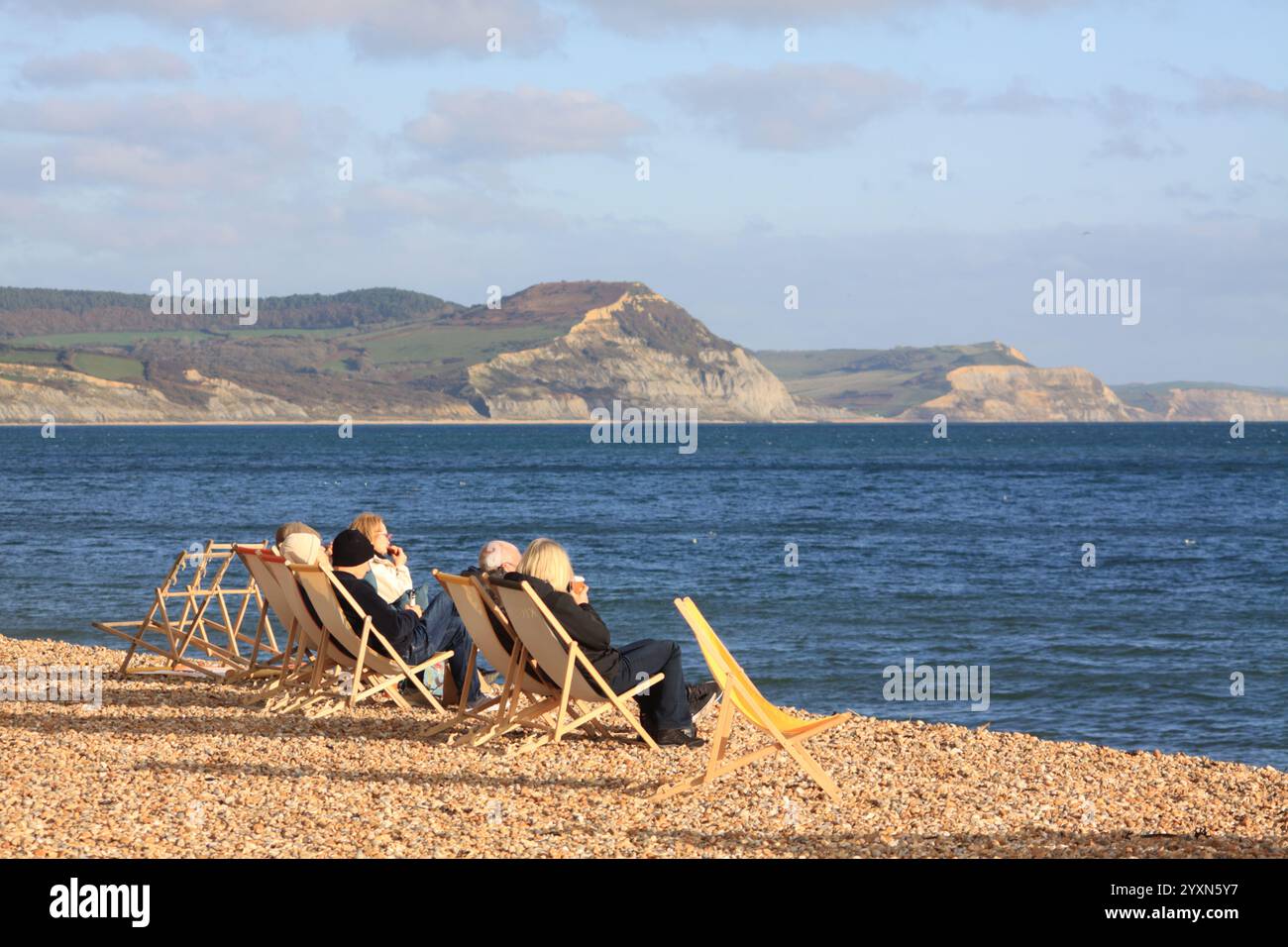 People enjoying deck chair pleasure in the Winter Lyme Regis Dorset ...