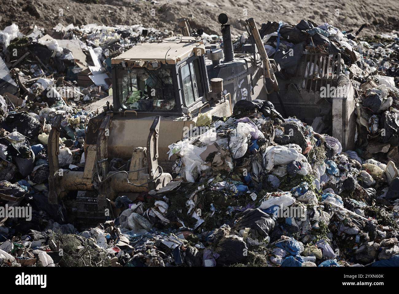 Heavy machinery shredding garbage in an open air landfill. Waste Stock ...