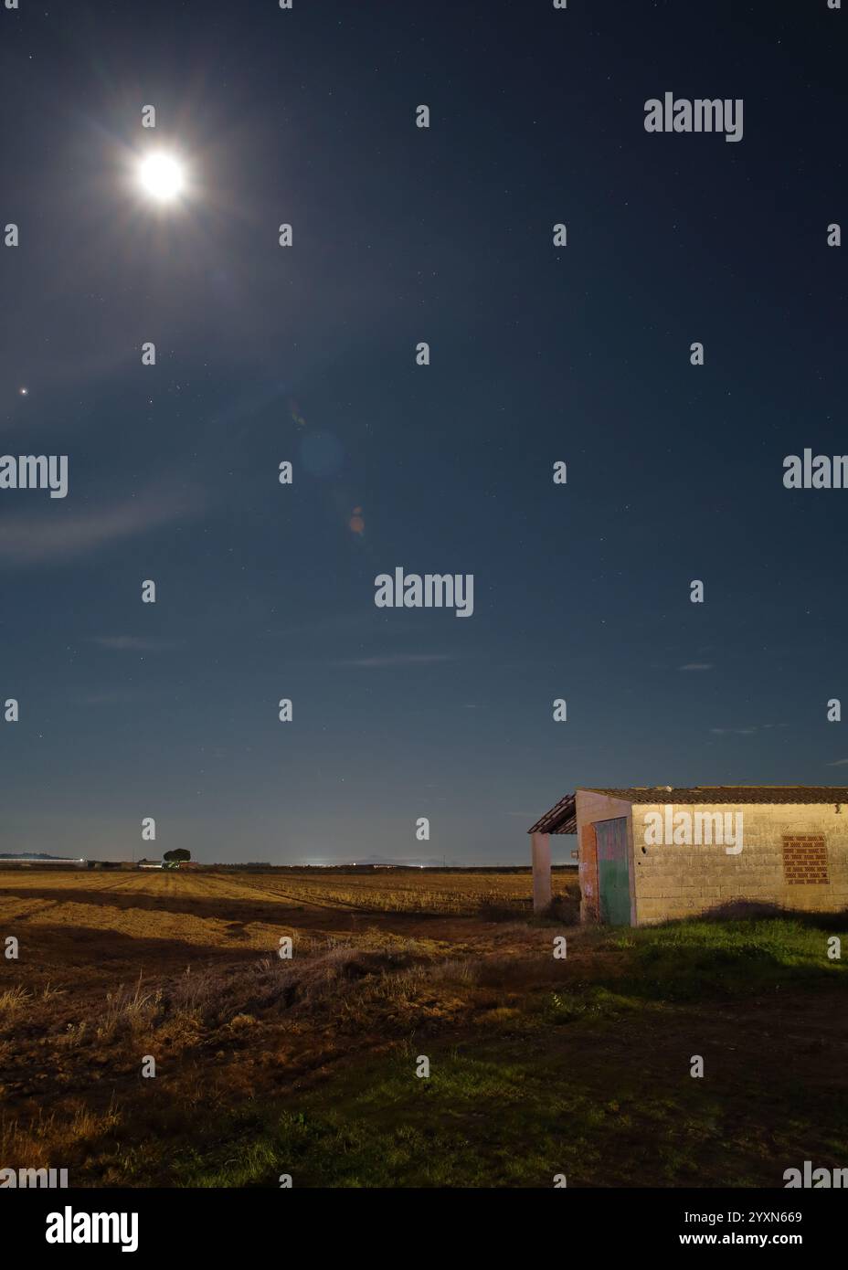 Night view of a farmland with a full moon where a tool shed can also be ...