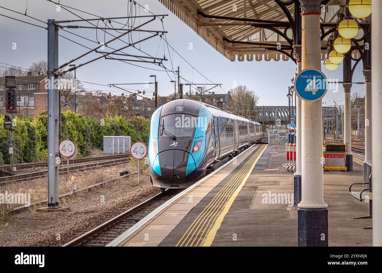 A train departs a railway station between passing a historic platform ...
