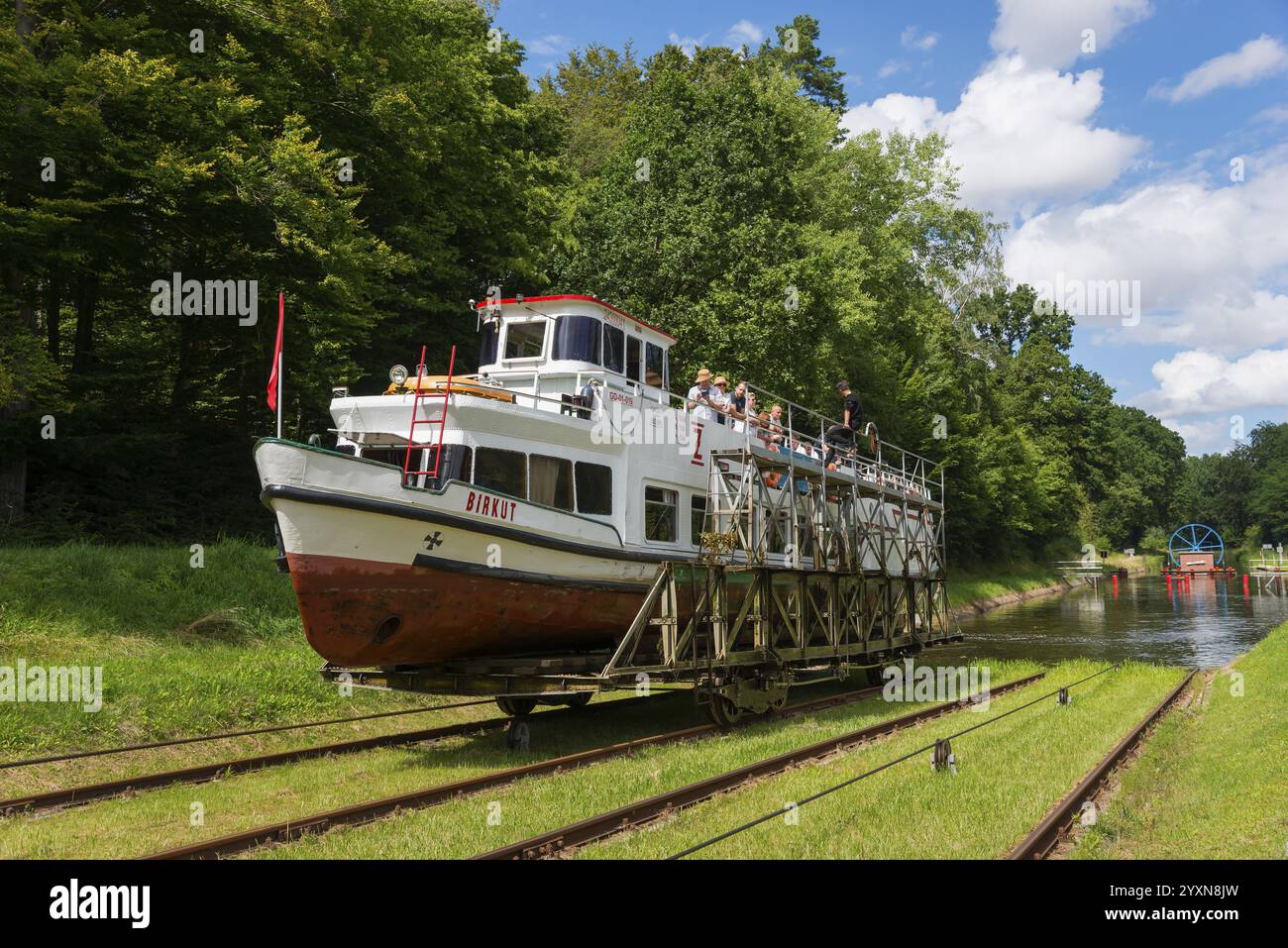 A boat being transported overland on a railway wagon, surrounded by ...