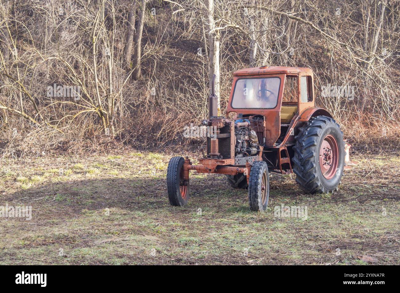 Antique tractor. An old rusty red tractor on a farm in the woods Stock ...