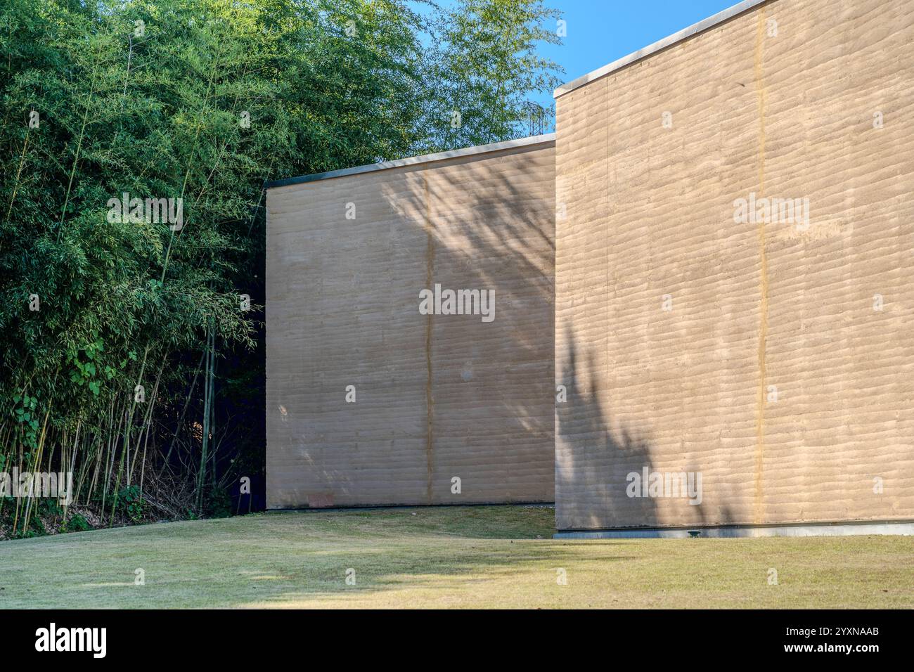 Thickly compacted earth walls of an art museum, illuminated by warm ...