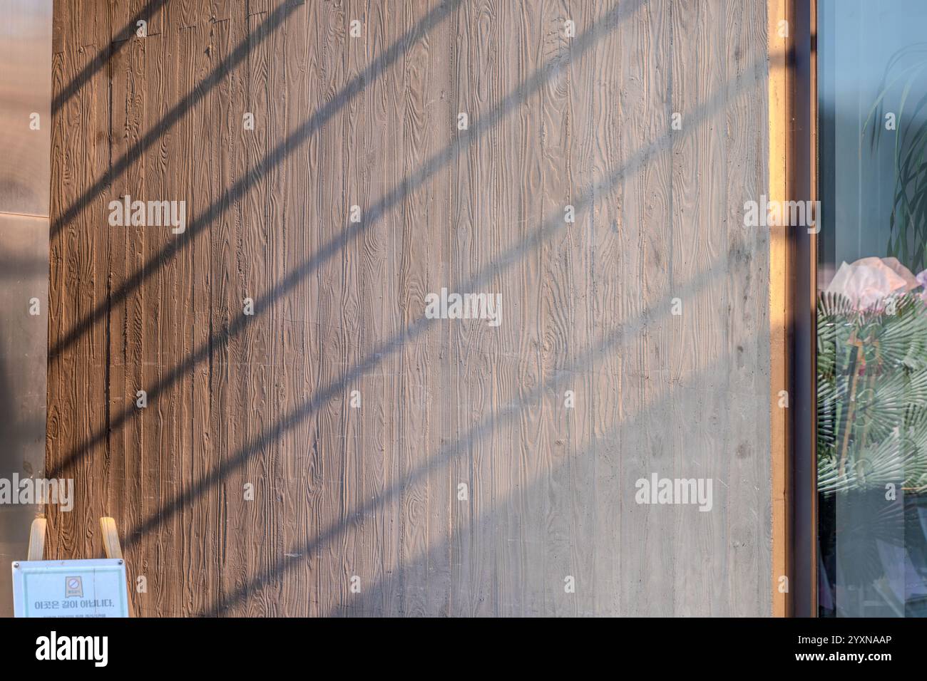 A warm glow highlights the texture of an exposed concrete wall ...
