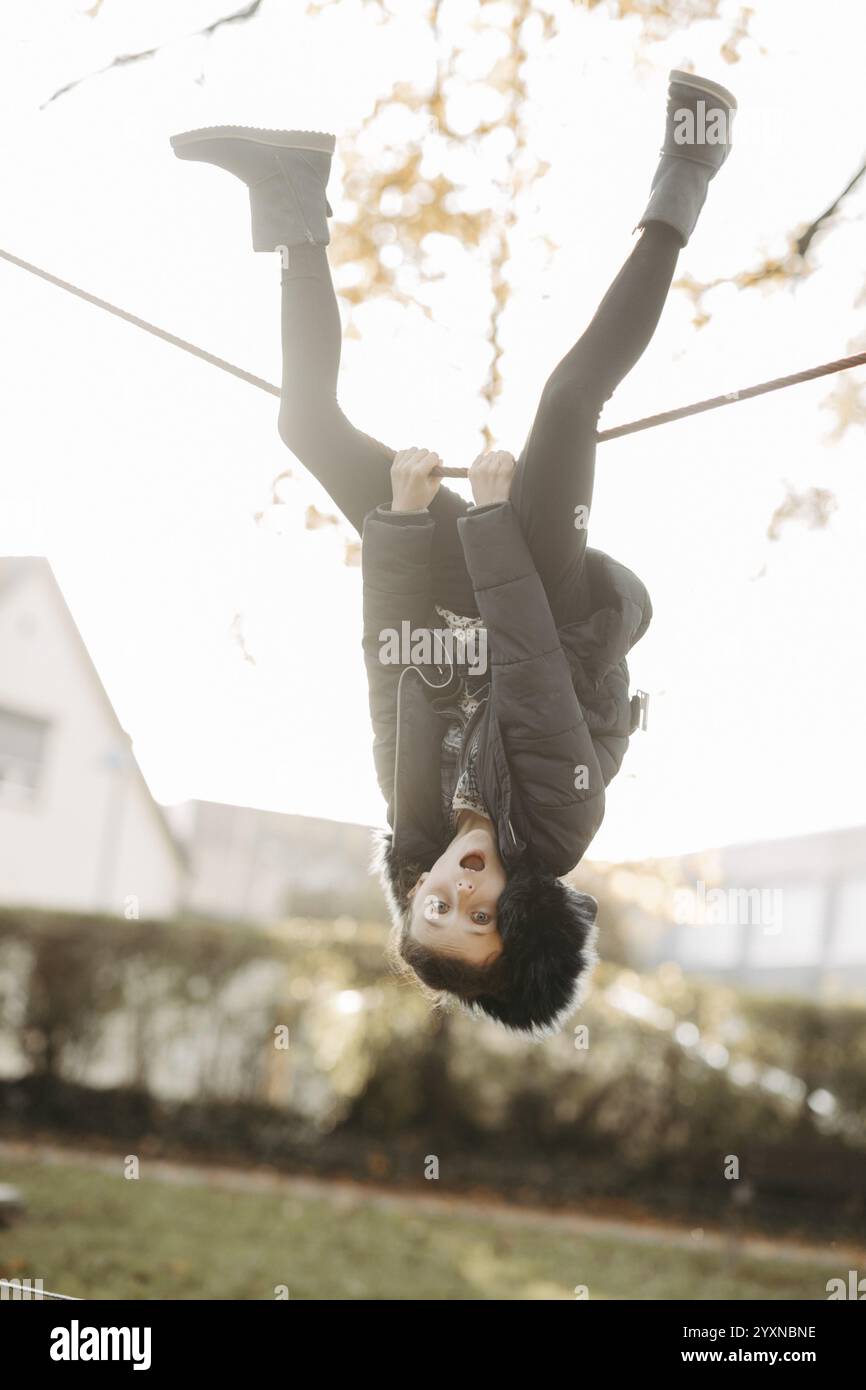 Girl hanging upside down on a gym rope at the playground Stock Photo ...