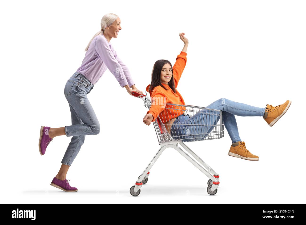 Woman pushing a friend inside a shopping cart isolated on white ...
