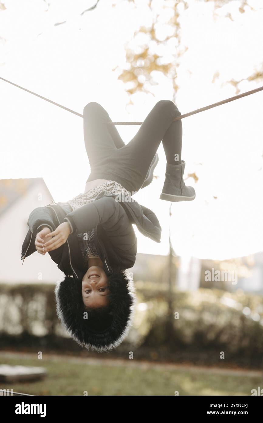 Girl hanging upside down on a gym rope at the playground Stock Photo - Alamy