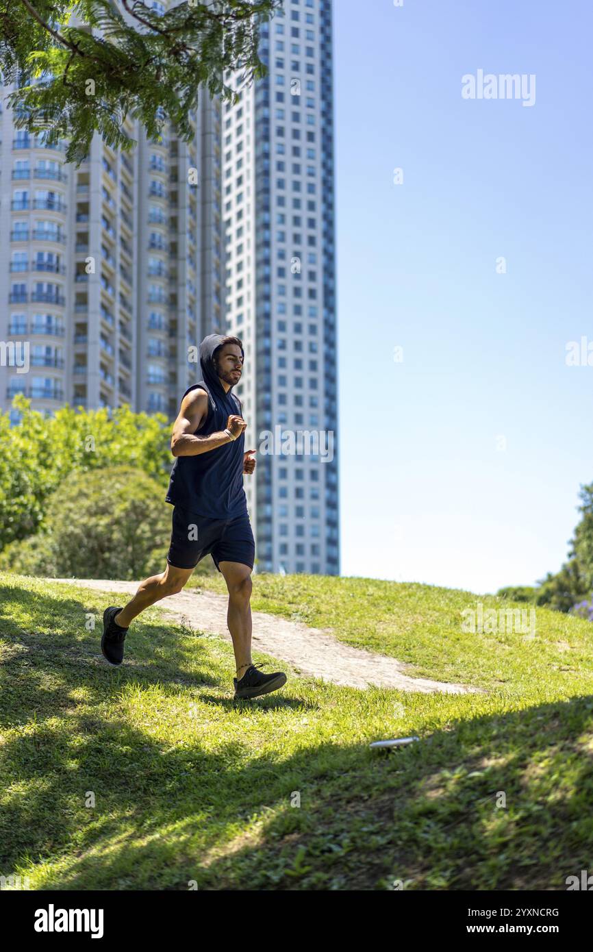 Athletic young man tackling ups and downs while jogging in an urban ...
