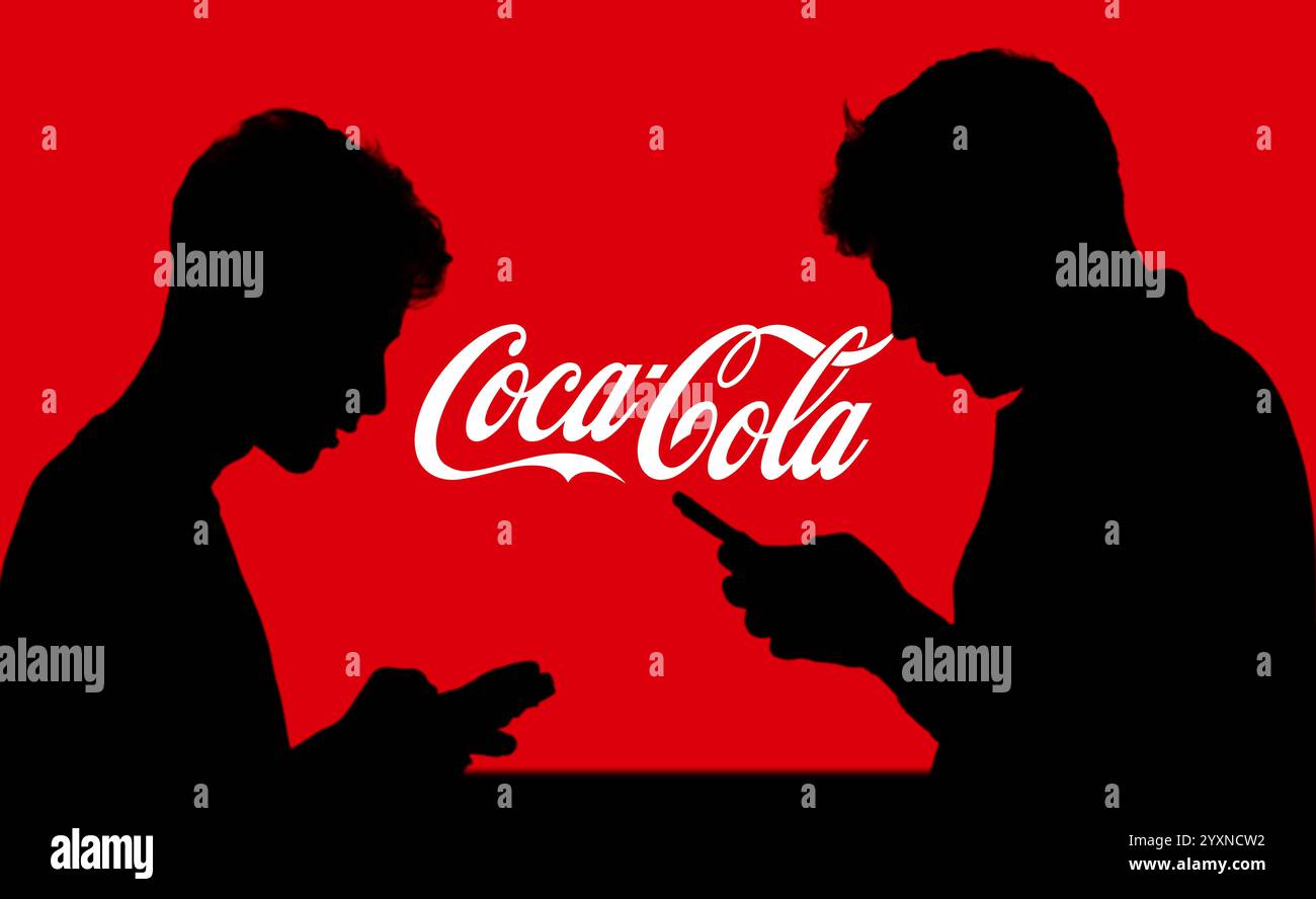 Coca-Cola logo is seen on a mobile phone and a computer screen Stock ...