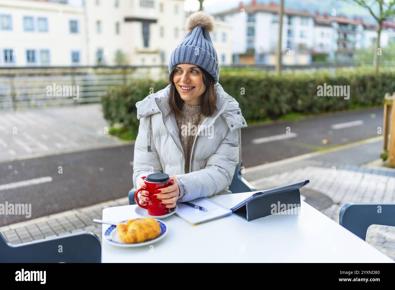Beauty woman wearing warm clothes and woolly hat warming hands with hot ...