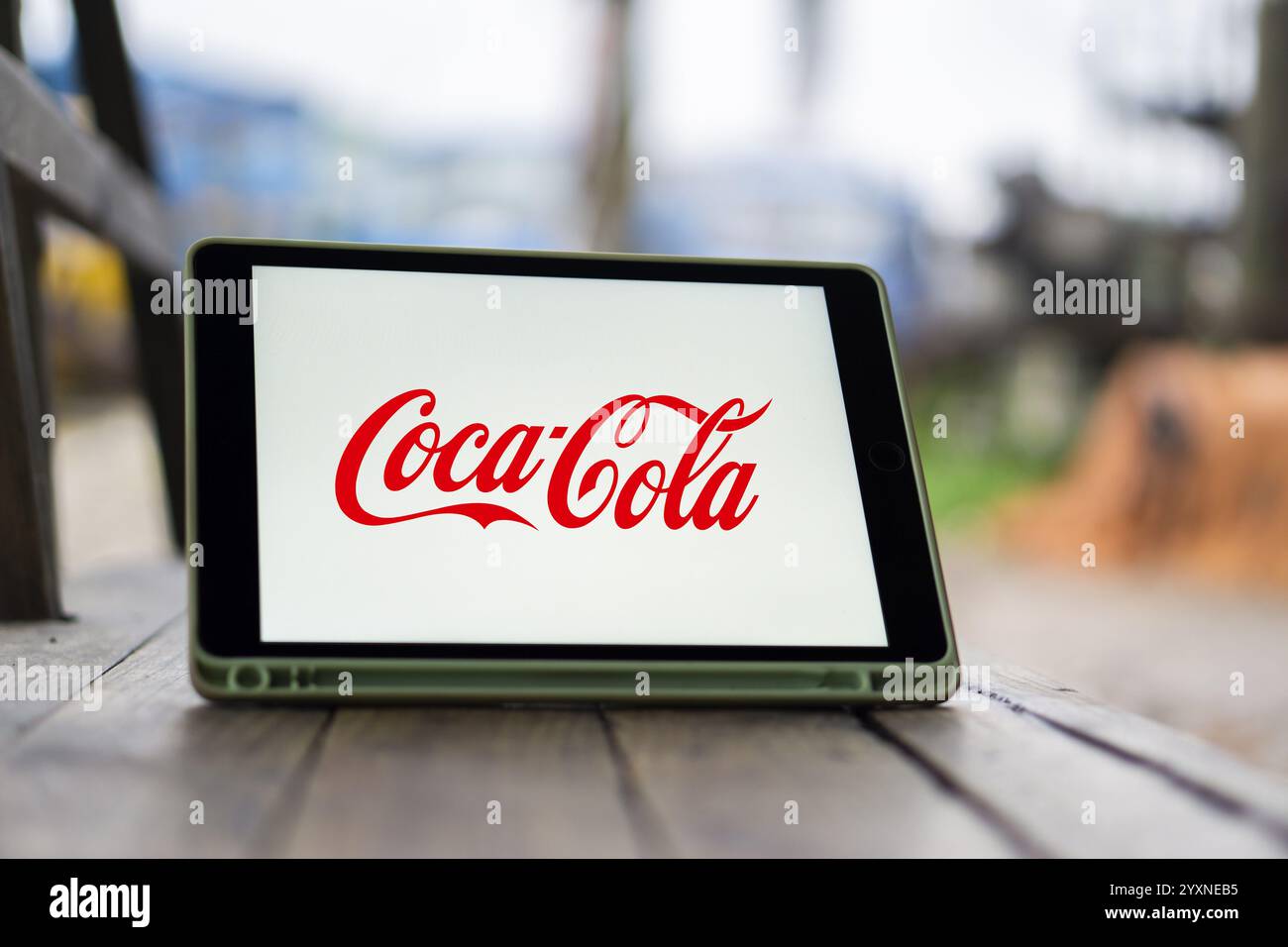 Coca-Cola logo is seen on a mobile phone and a computer screen Stock ...