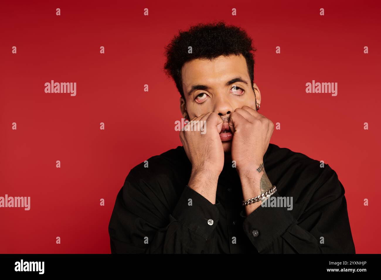 The young man shows a playful expression while playfully stretching his ...