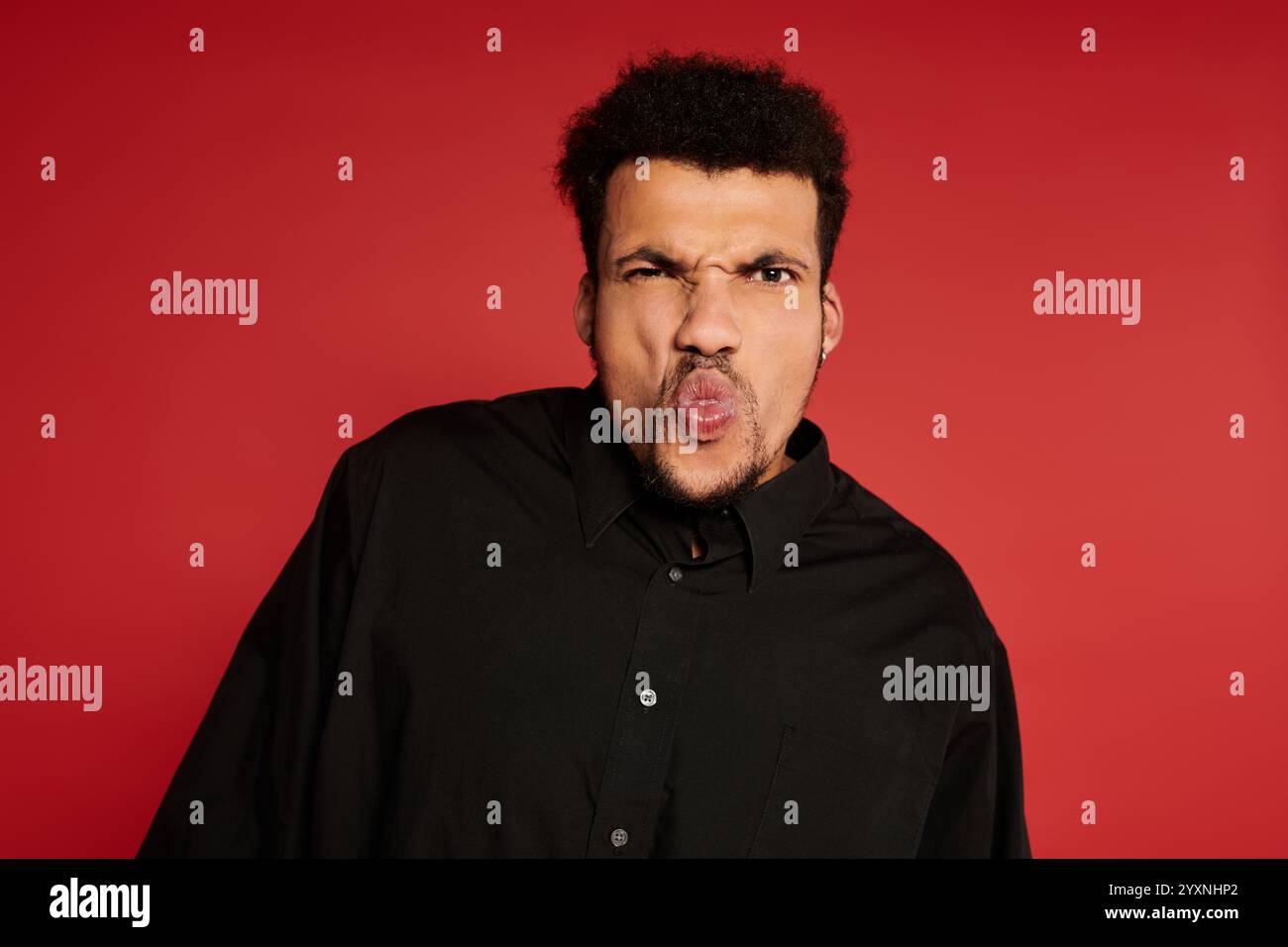 A young handsome man displays a playful expression while posing for the ...